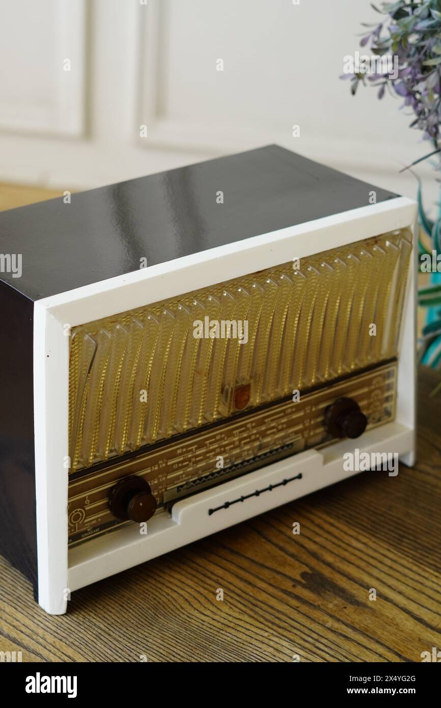 An old vintage style radio placed on a wooden table with a white ...