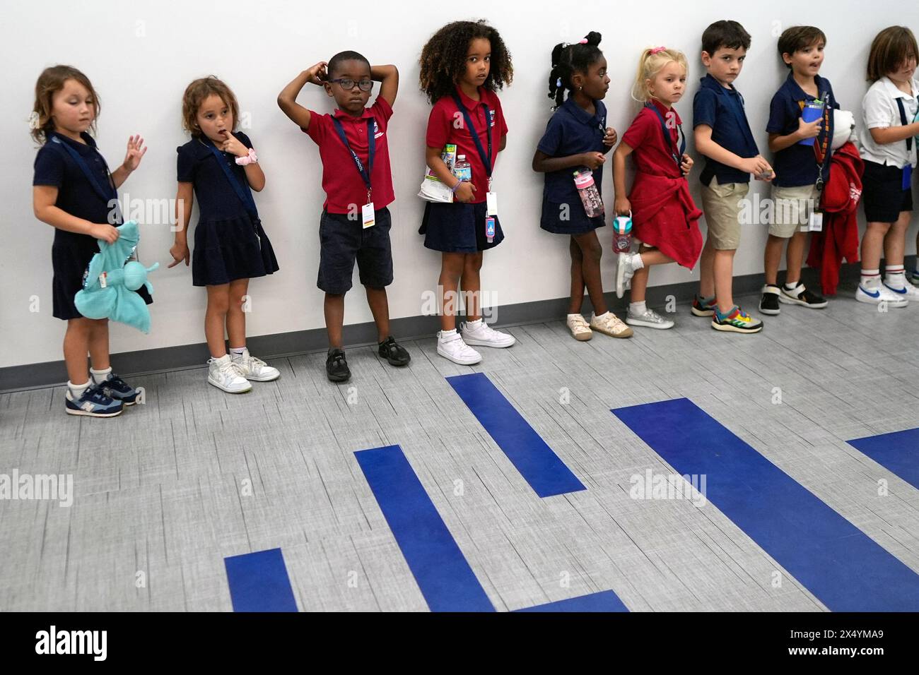 Elementary school students line up in a hall on their way to a class at ...