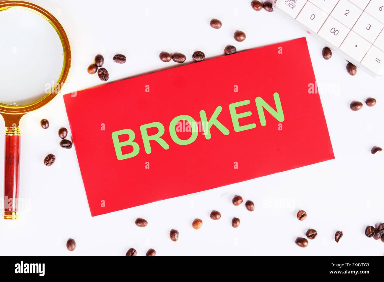 A word Broken on red paper on a white background with coffee beans and ...
