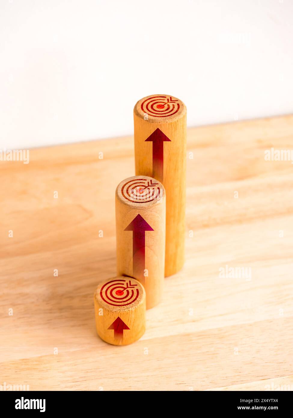 Target icons and rise arrows on round wooden sticks as business graph ...
