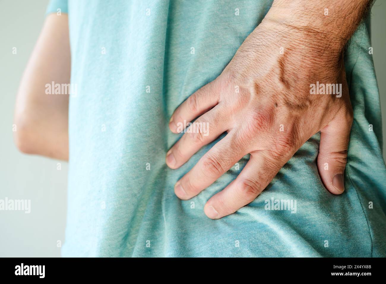 Back pain symptoms, close up of male hand holding the painful sport on ...