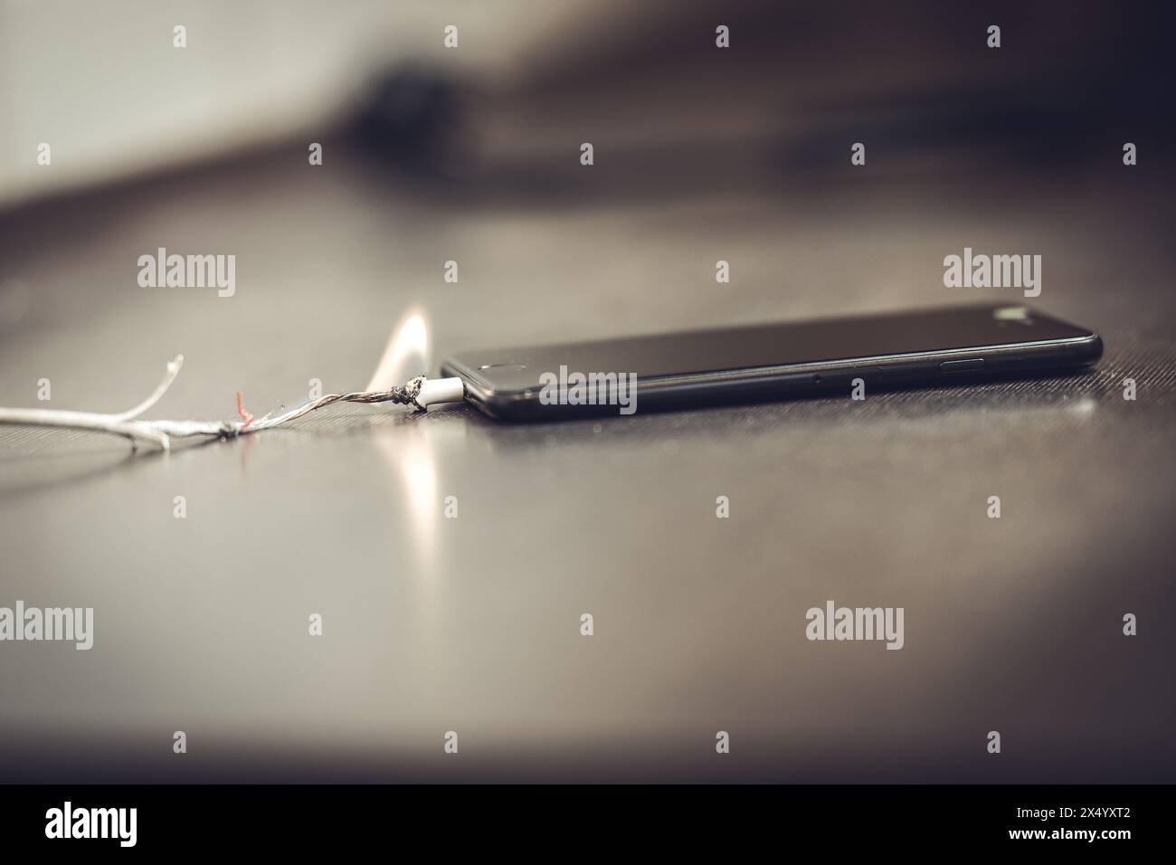 Phone charging cable catches fire. Danger of using a broken cable Stock ...