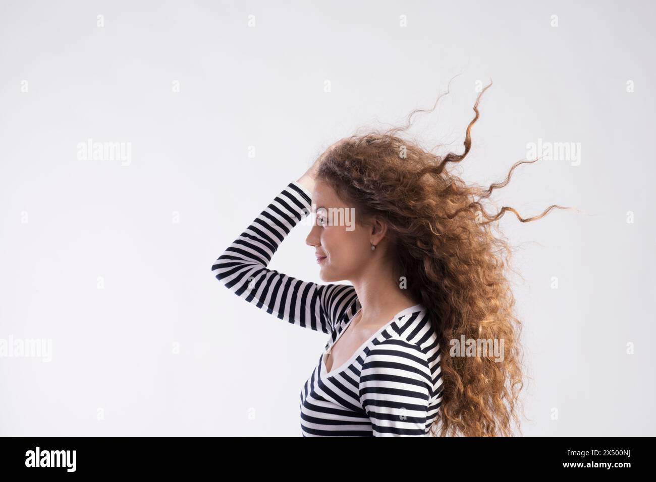 Portrait of a gorgeous teenage girl with curly hair, blowing in wind ...