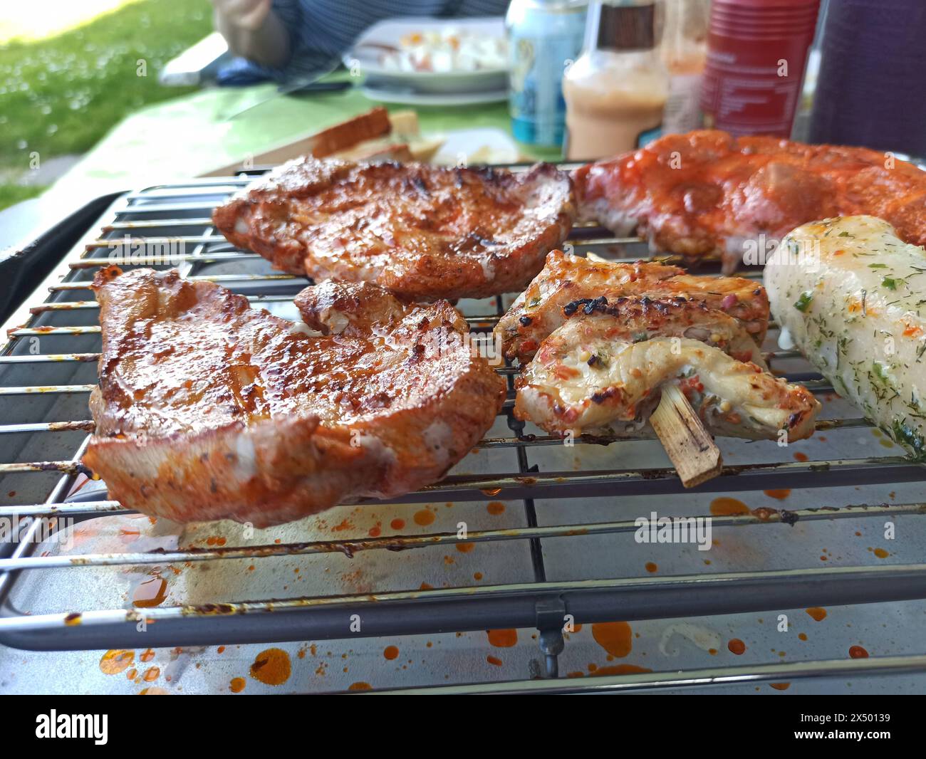 Grillgut auf einem Tischgrill im eigenen Garten. Grillsaison 2024 ...