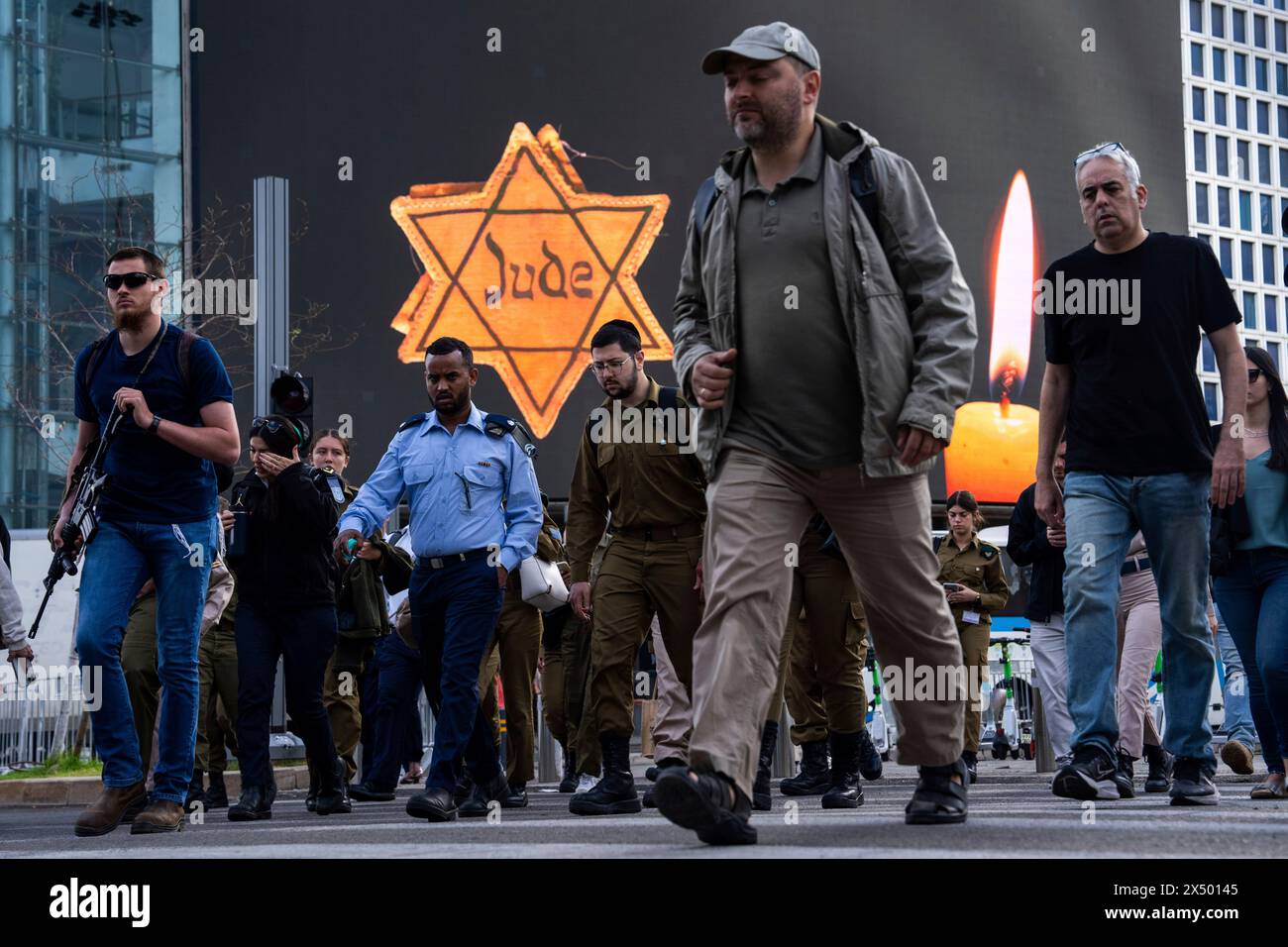 People walk next to a billboard showing a yellow Star of David that ...