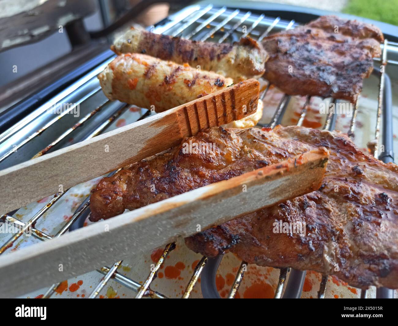 Grillgut auf einem Tischgrill im eigenen Garten. Grillsaison 2024 ...