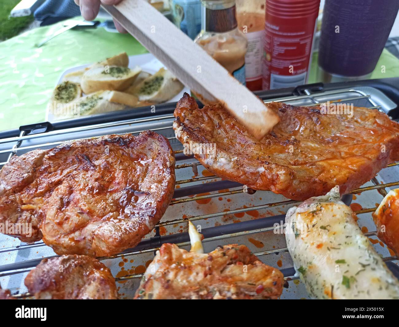 Grillgut auf einem Tischgrill im eigenen Garten. Grillsaison 2024 ...