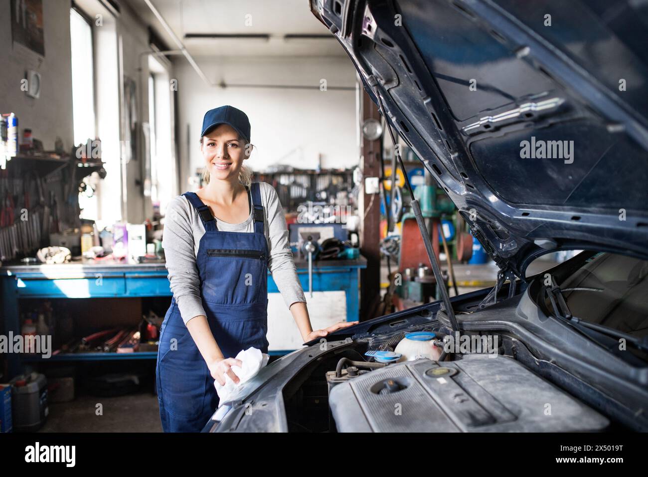 Female auto mechanic repairing, maintaining car. Beautiful woman ...