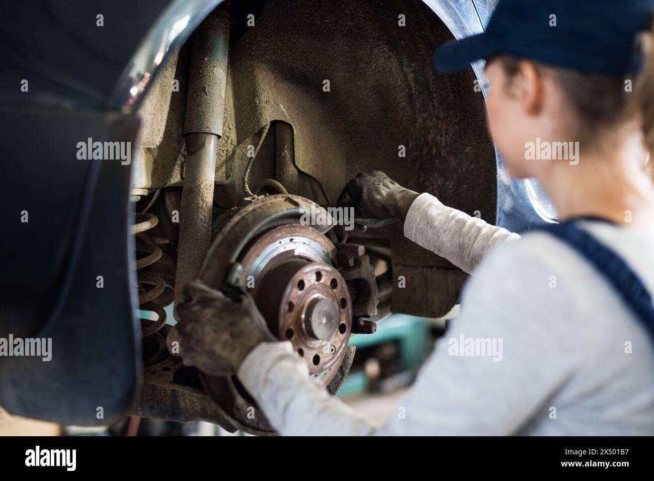 Female auto mechanic elevating car on car lift, checking breaks ... Female auto mechanic elevating car on car lift, checking breaks ...