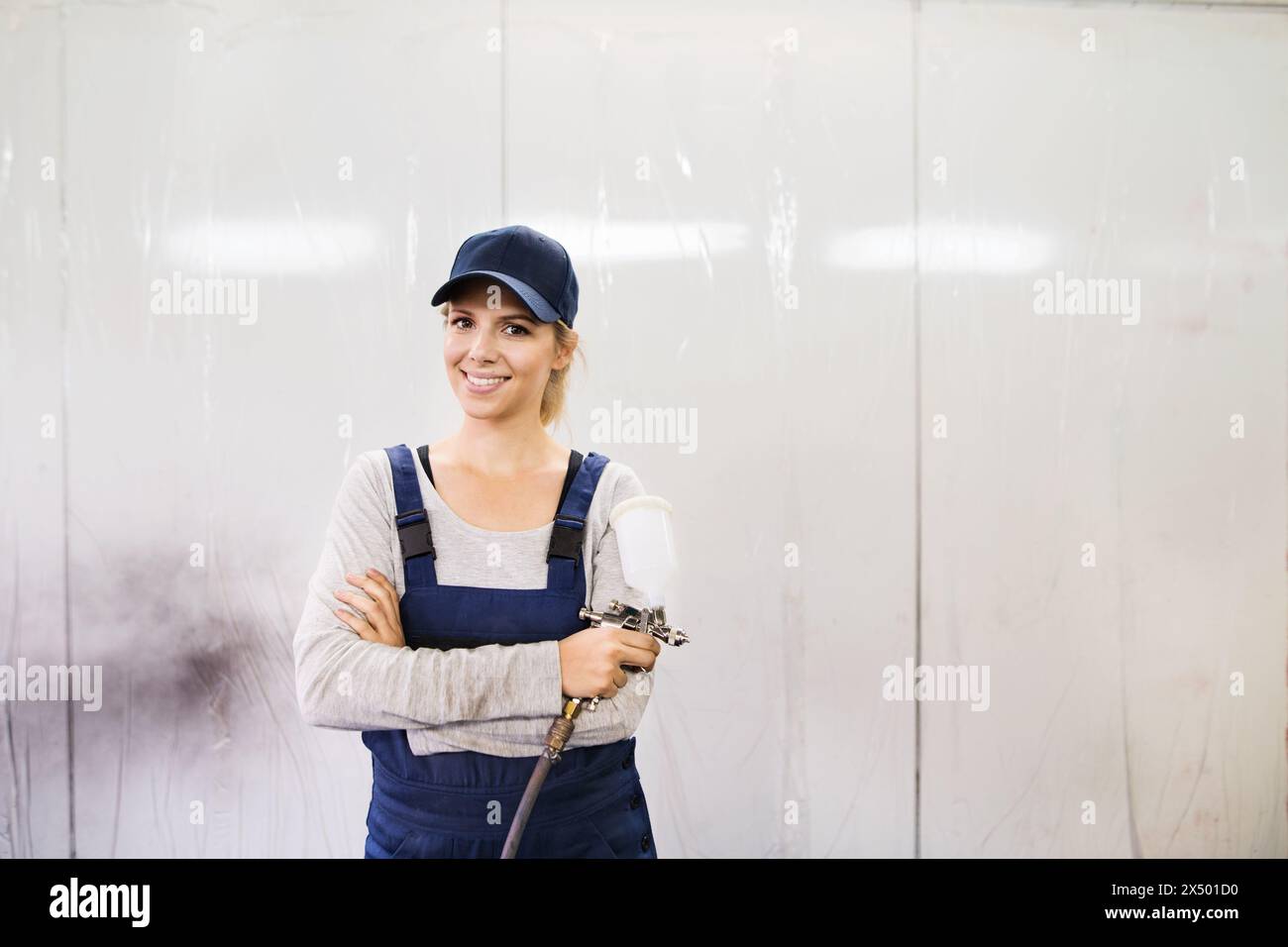 Female car painter, paingting vehicles in auto body shop. Young woman ...