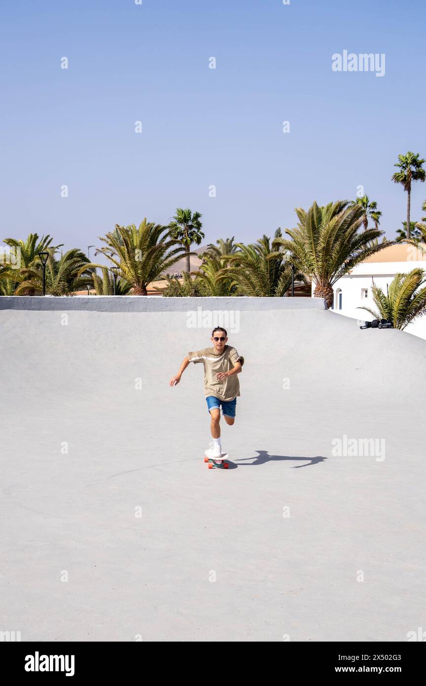 A young man is captured mid-ride as he skillfully maneuvers a surfskate ...