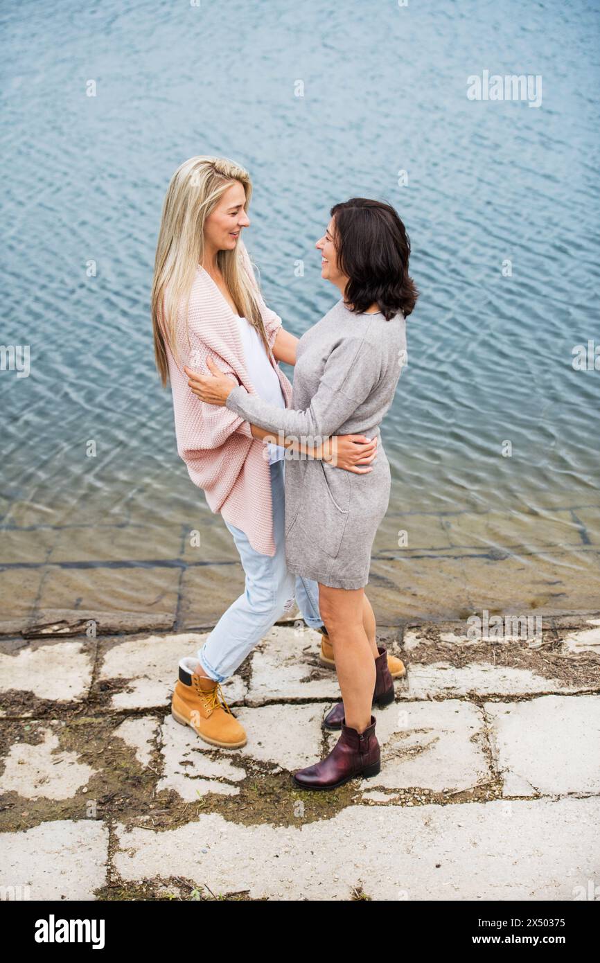 Mom and daughter on spring vacation together by lake. Mother and ...
