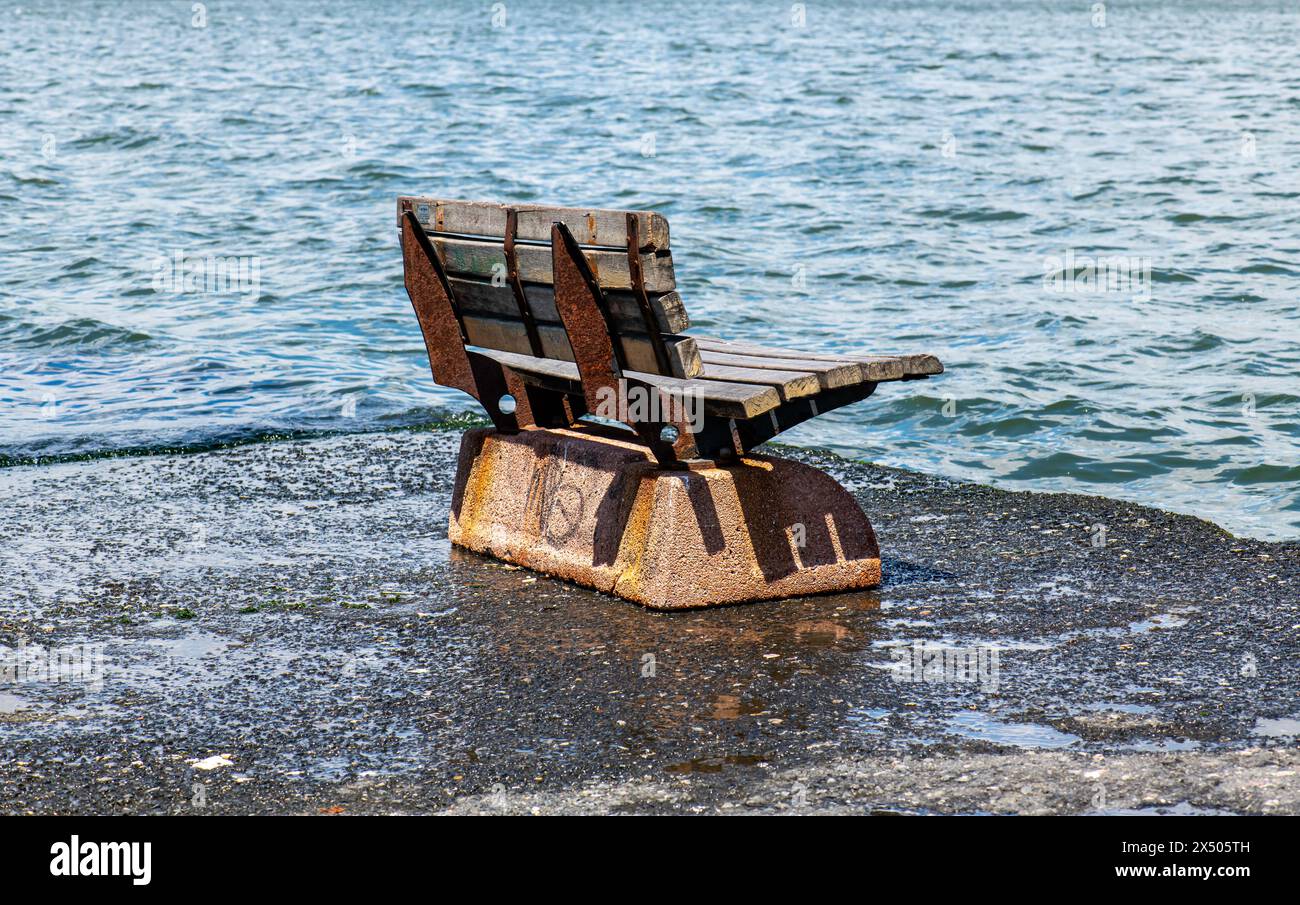 The smell of loneliness when the sea rises, a public bench made of ...