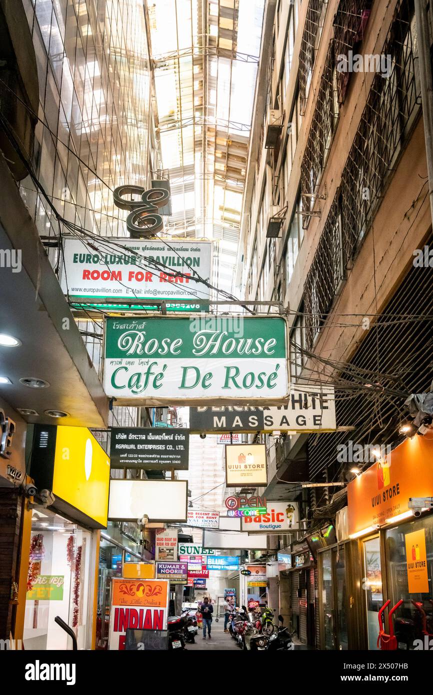 Looking down a tight packed alley with small shops, markets stalls and ...