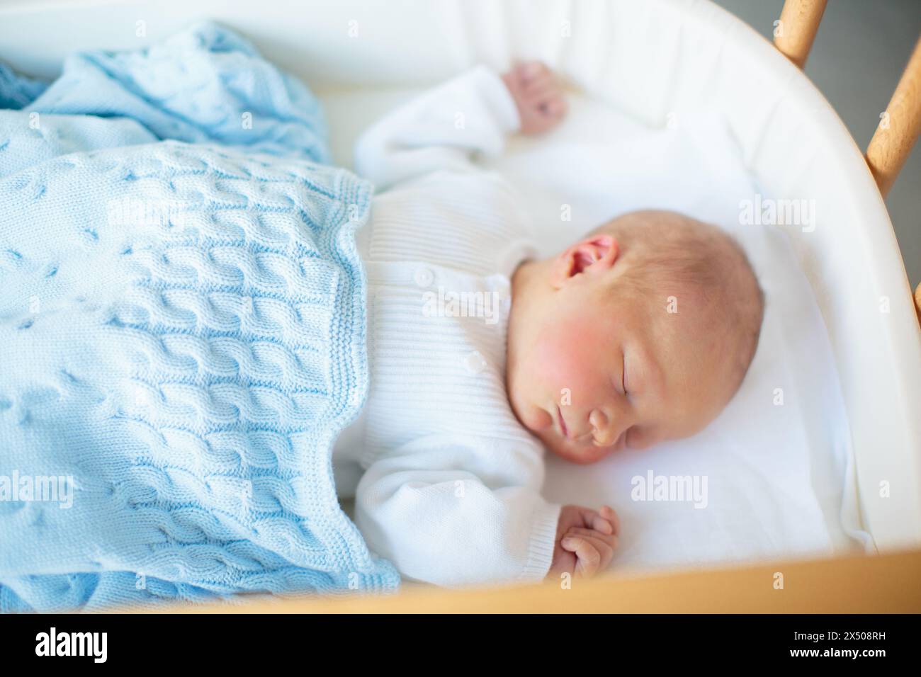 Newborn baby in hospital room. New born child in wooden co-sleeper crib ...