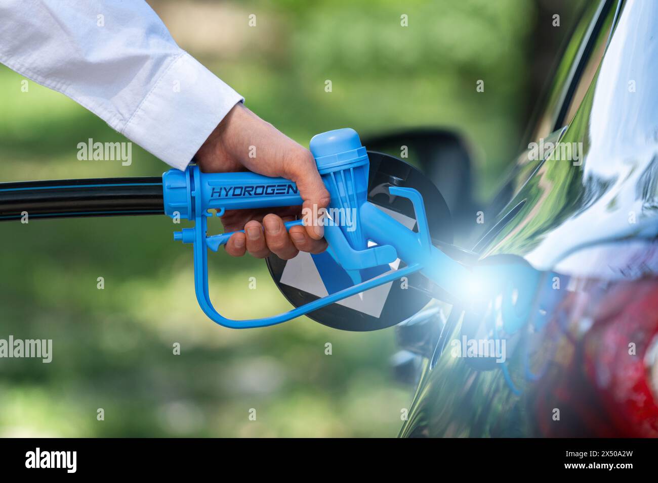 Man holds a hydrogen fueling nozzle. Refueling car with hydrogen fuel ...