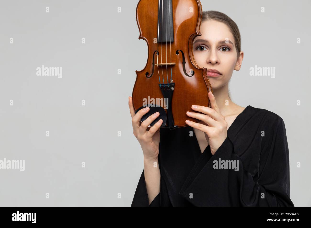 Woman musical artist holding violin Stock Photo - Alamy