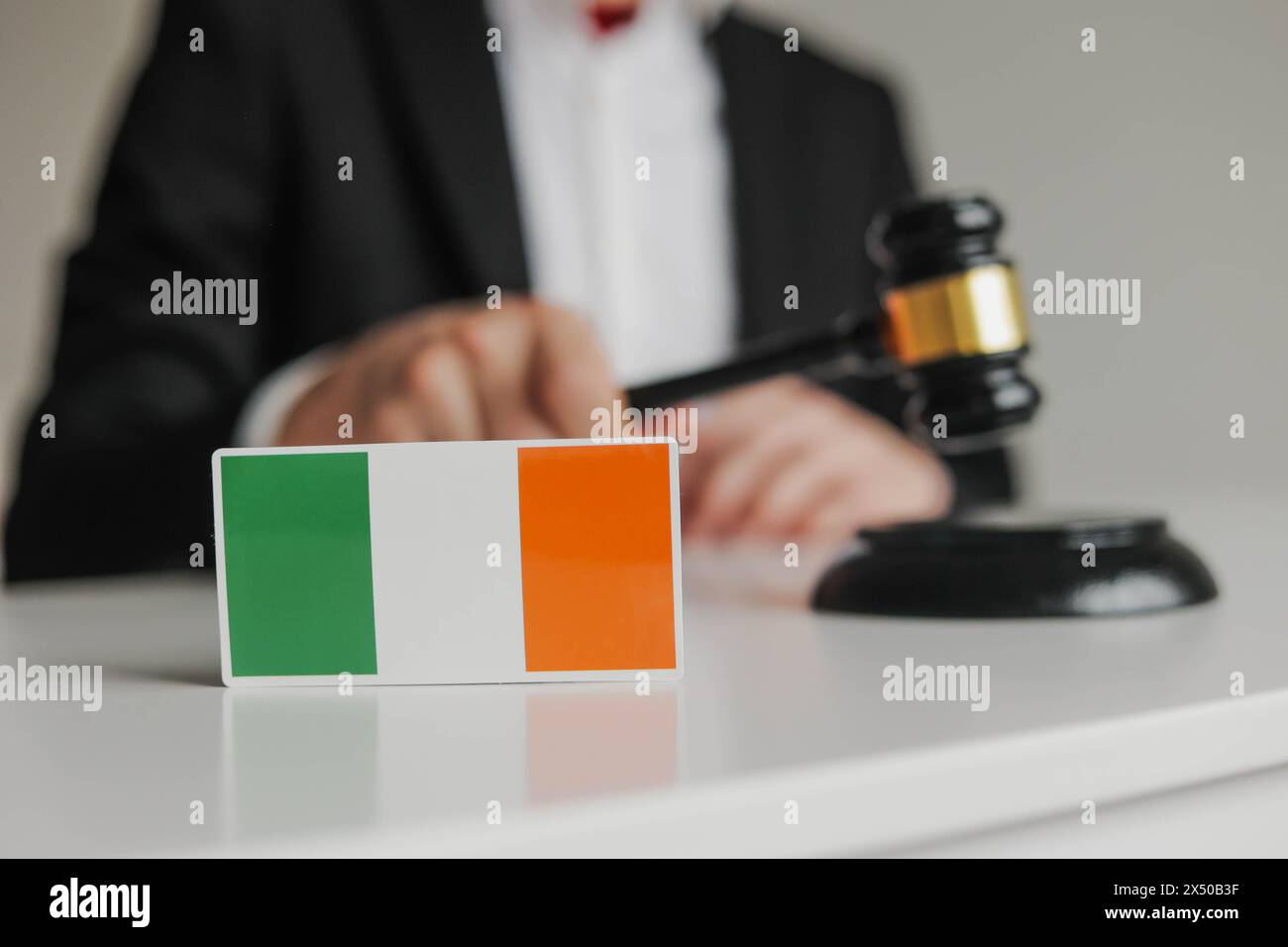Judge's hand holding wooden gavel. Flag of Ireland. Concept of Irish ...