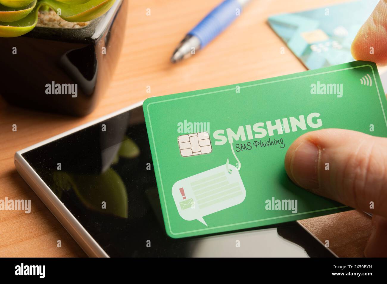Smishing (SMS message phishing) concept: man hold a credit card over a ...