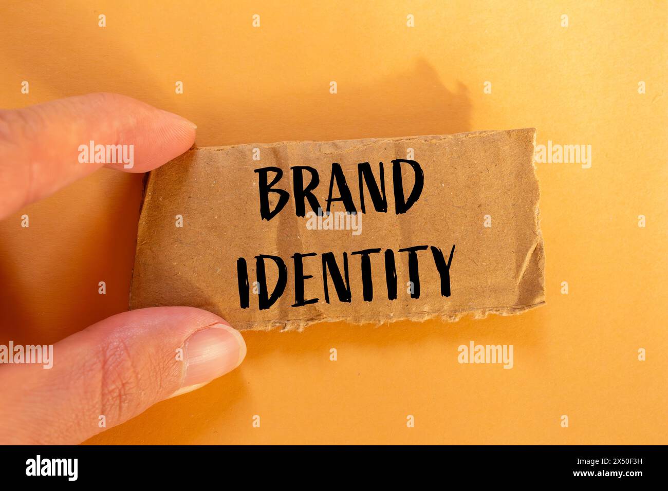 Brand identity words written on ripped cardboard paper piece with ...