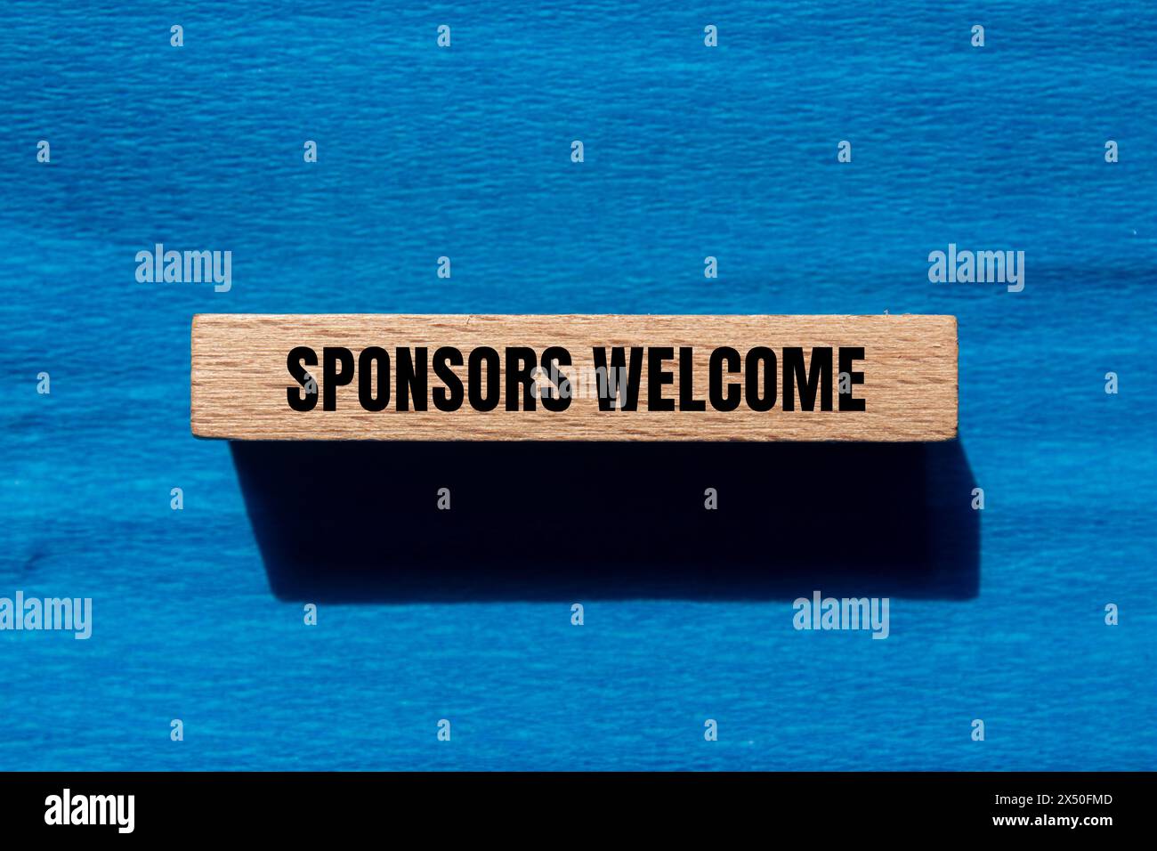 Sponsors welcome words written on wooden block with blue background ...