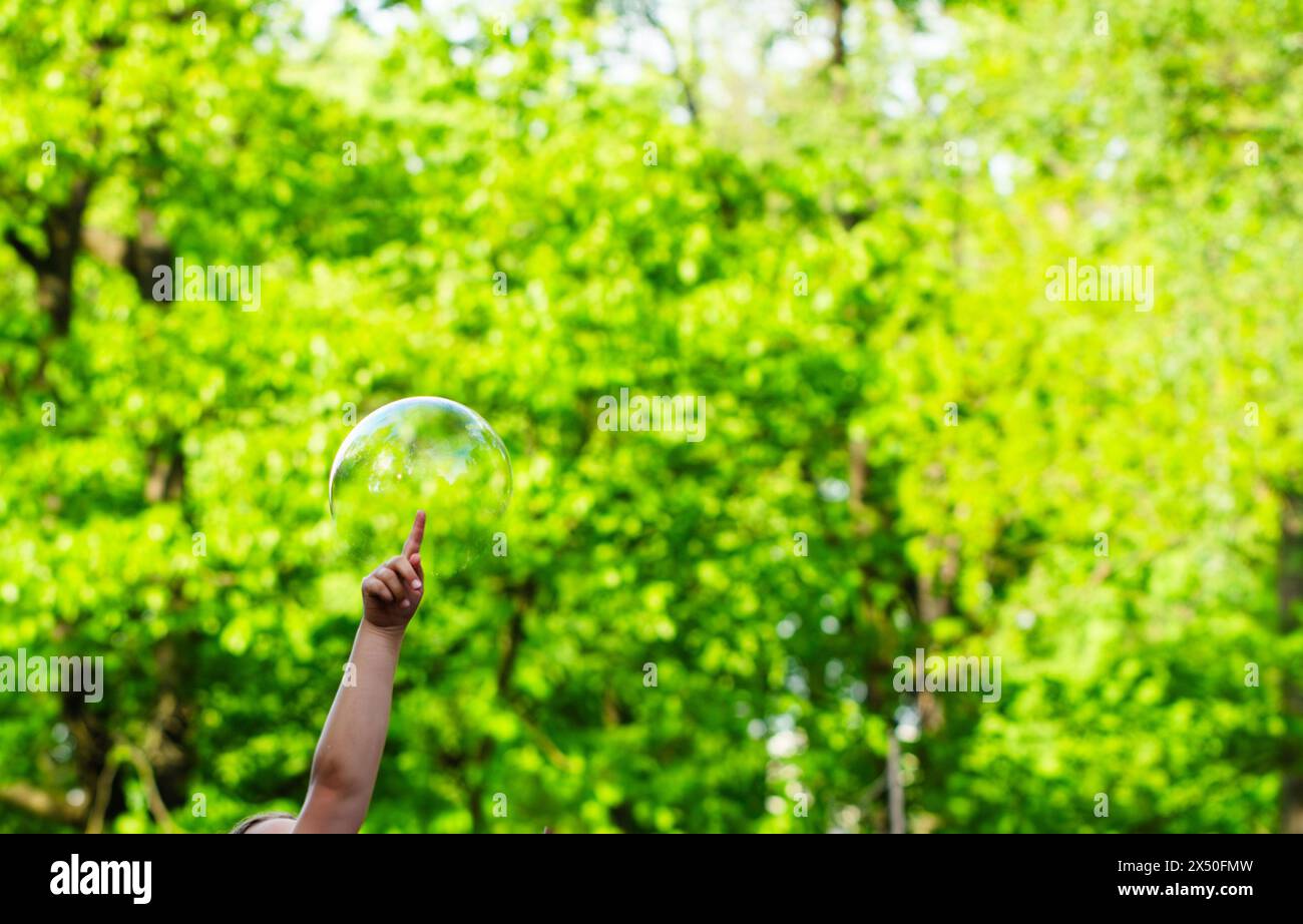 child trying to burst soap bubbles, festive atmosphere, sun rays ...