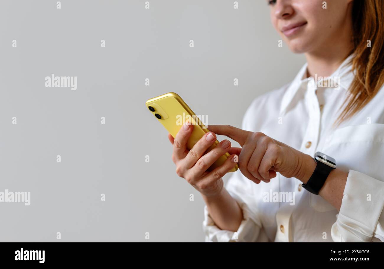 Young businesswoman online messaging using her smart phone. Touching ...