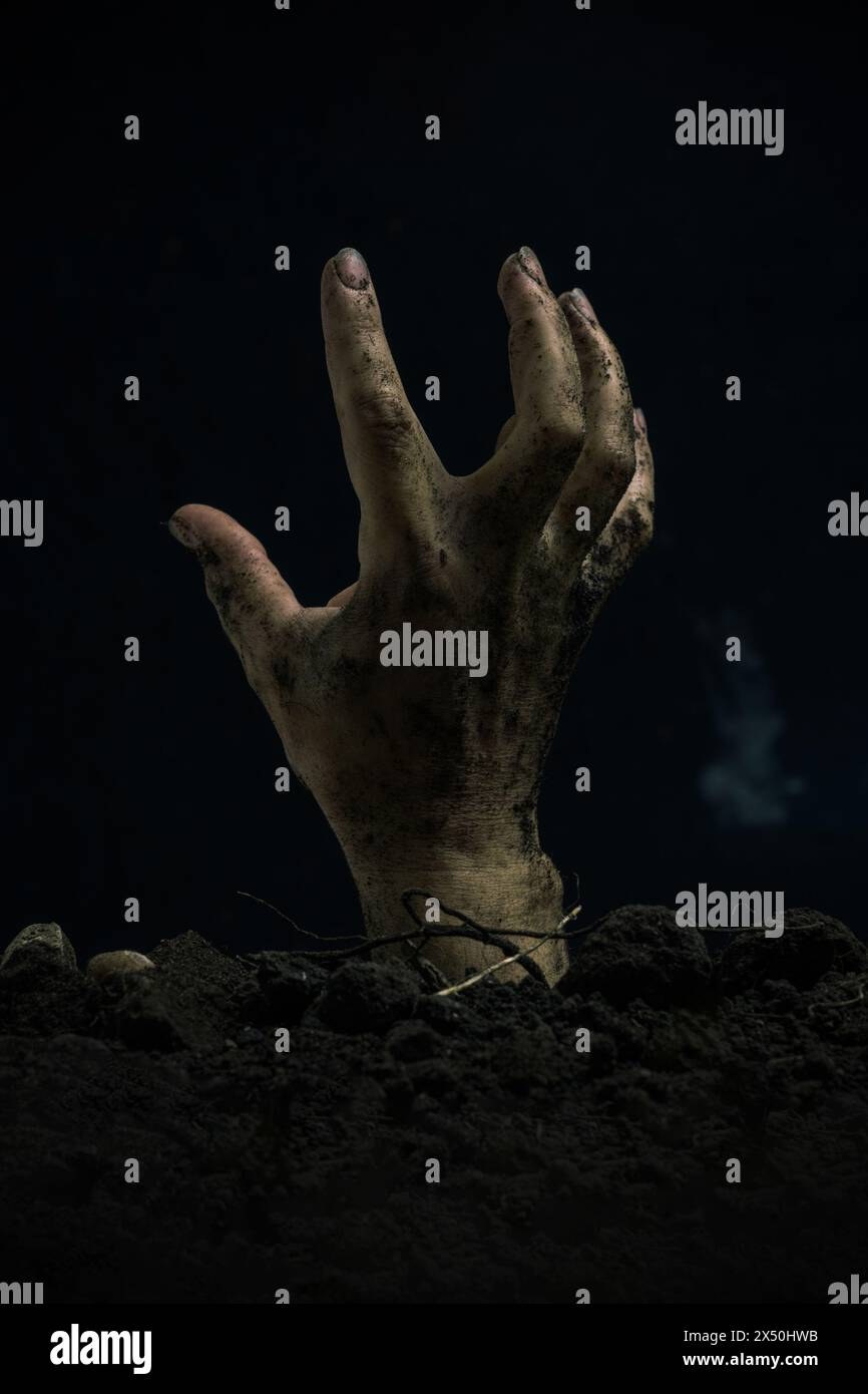 Zombie hand rising from the ground on black background. Halloween ...