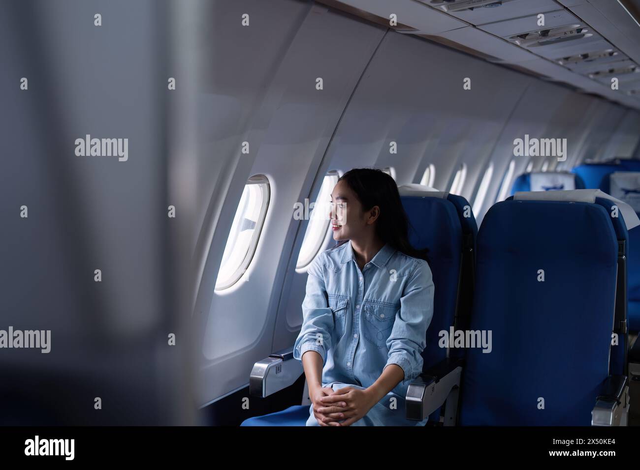 Asian people female person onboard, airplane window, using mobile while ...