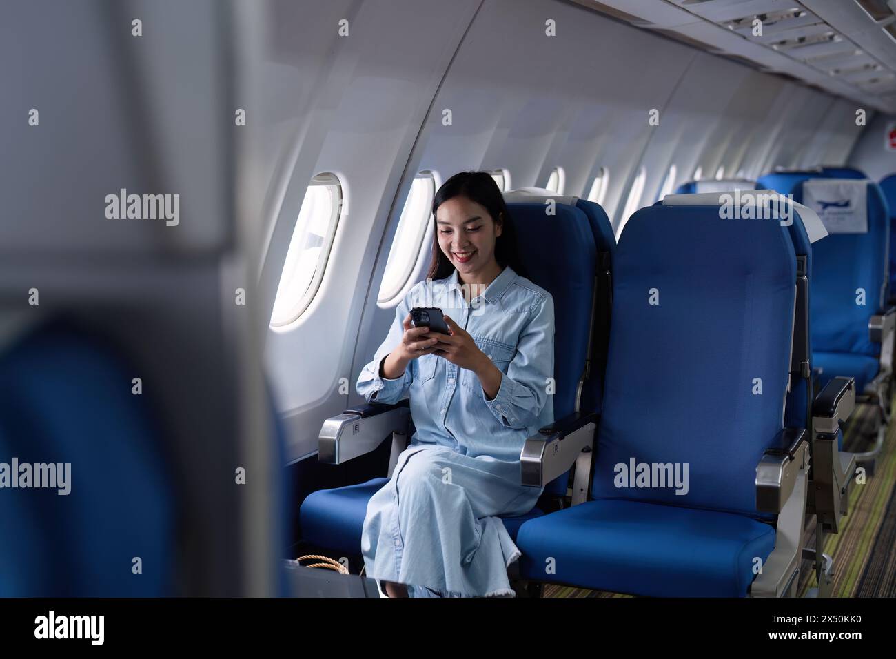 Asian people female person onboard, airplane window, using mobile while ...