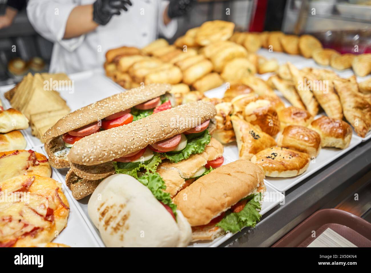 Fresh sandwiches, pies and pizza to choose from in the window of a cafe, buffet or self-service ...