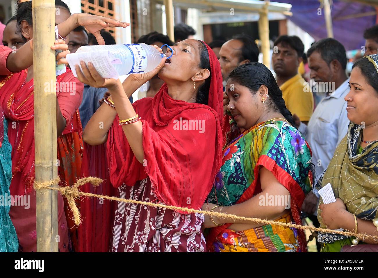 A woman takes a refreshing break while patiently waiting in line to ...
