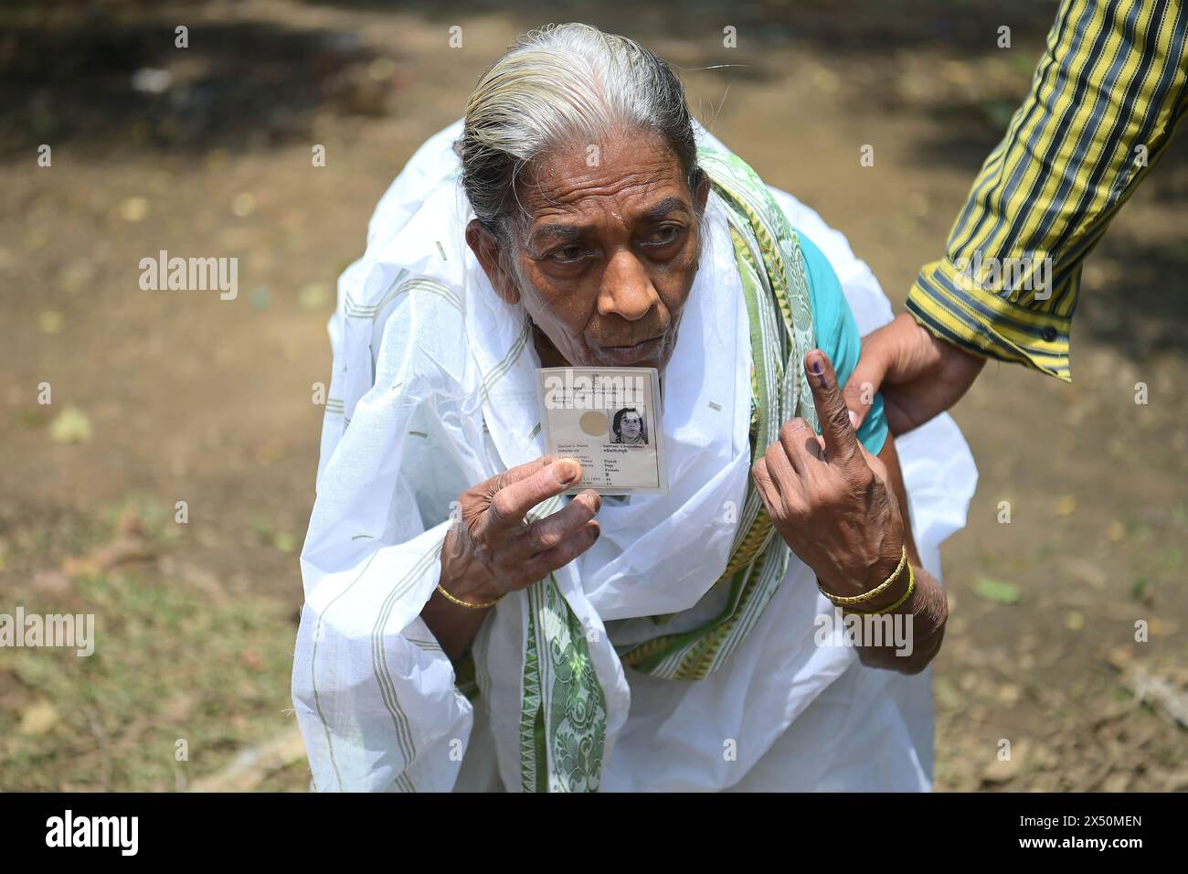 An elderly woman proudly displays her inked finger after voting at the ...