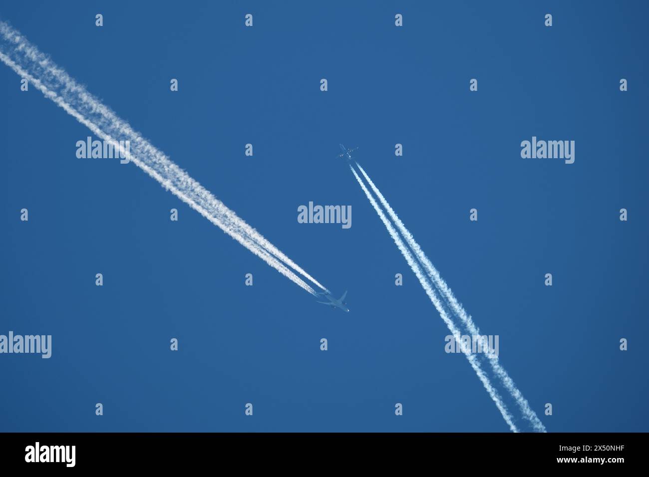 two planes in the sky, two parallel airplane tracks in the blue sky ...