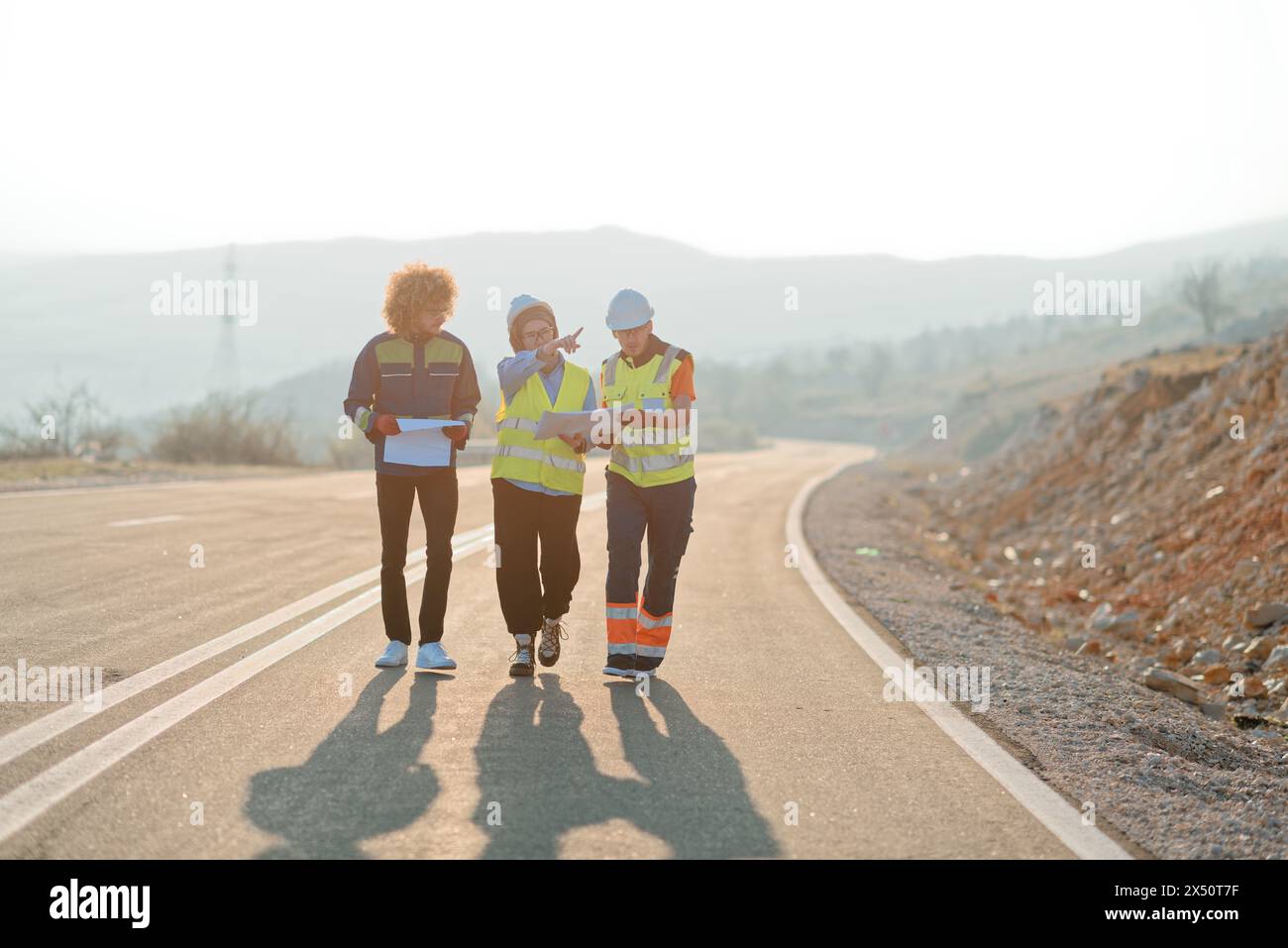 A team of engineers and workers oversees a wind turbine project at a ...