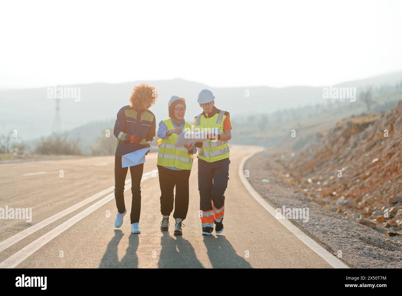 A team of engineers and workers oversees a wind turbine project at a ...