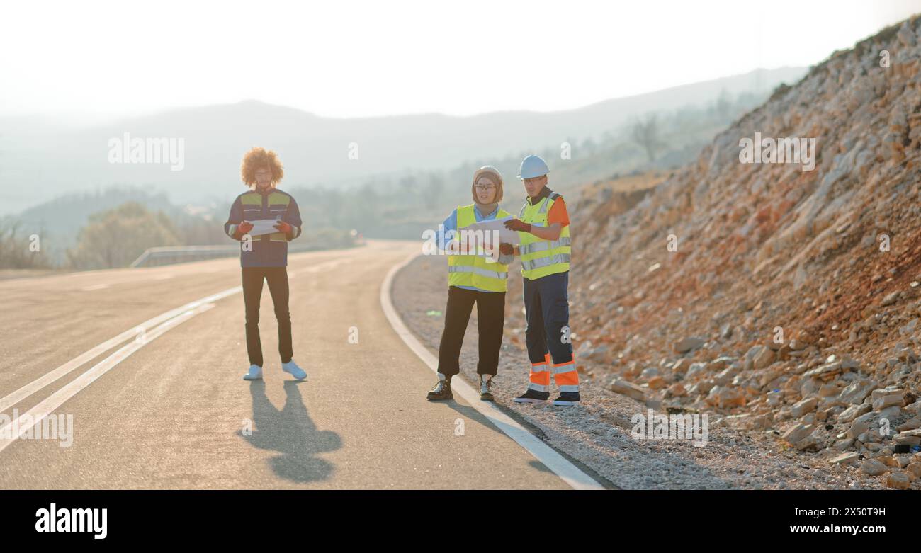 A team of engineers and workers oversees a wind turbine project at a ...