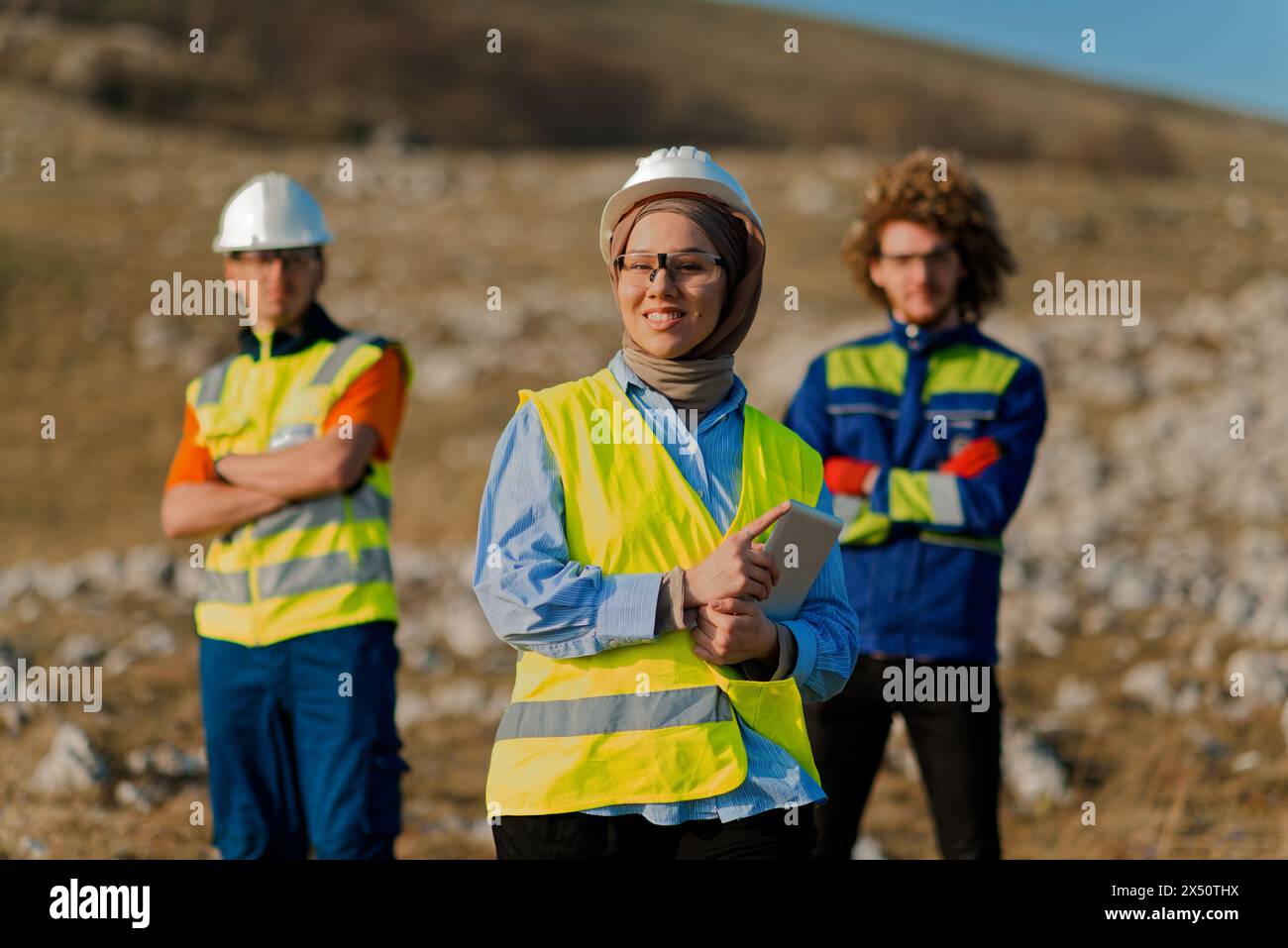 A team of engineers and workers oversees a wind turbine project at a ...