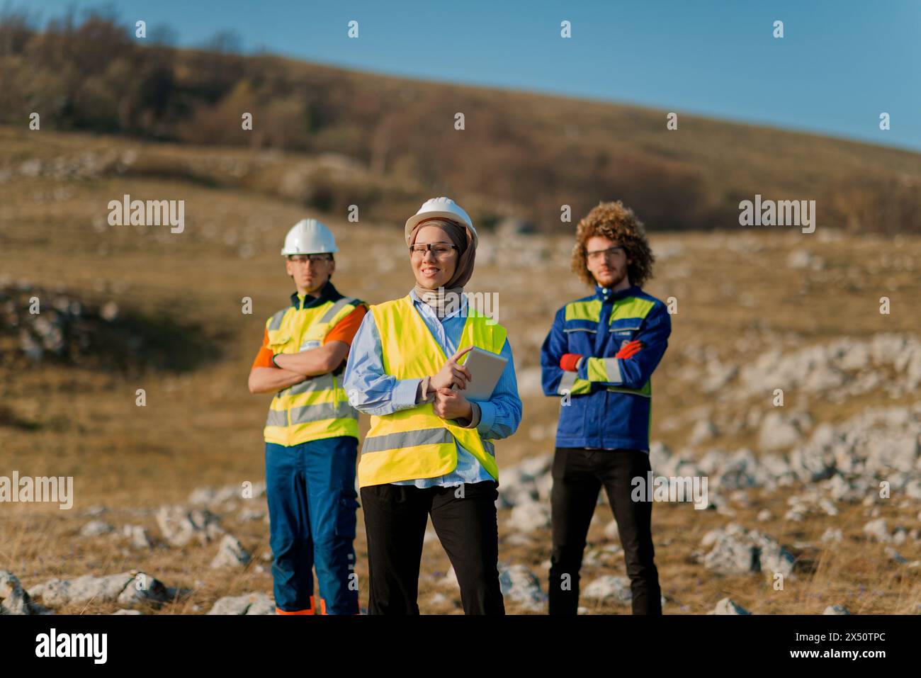 A team of engineers and workers oversees a wind turbine project at a ...