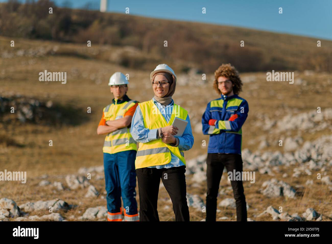 A team of engineers and workers oversees a wind turbine project at a ...