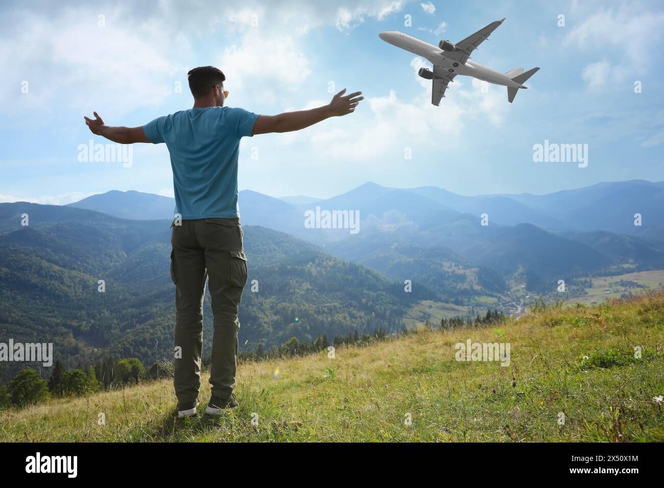 Man looking at airplane flying in sky over mountains, back view Stock ...