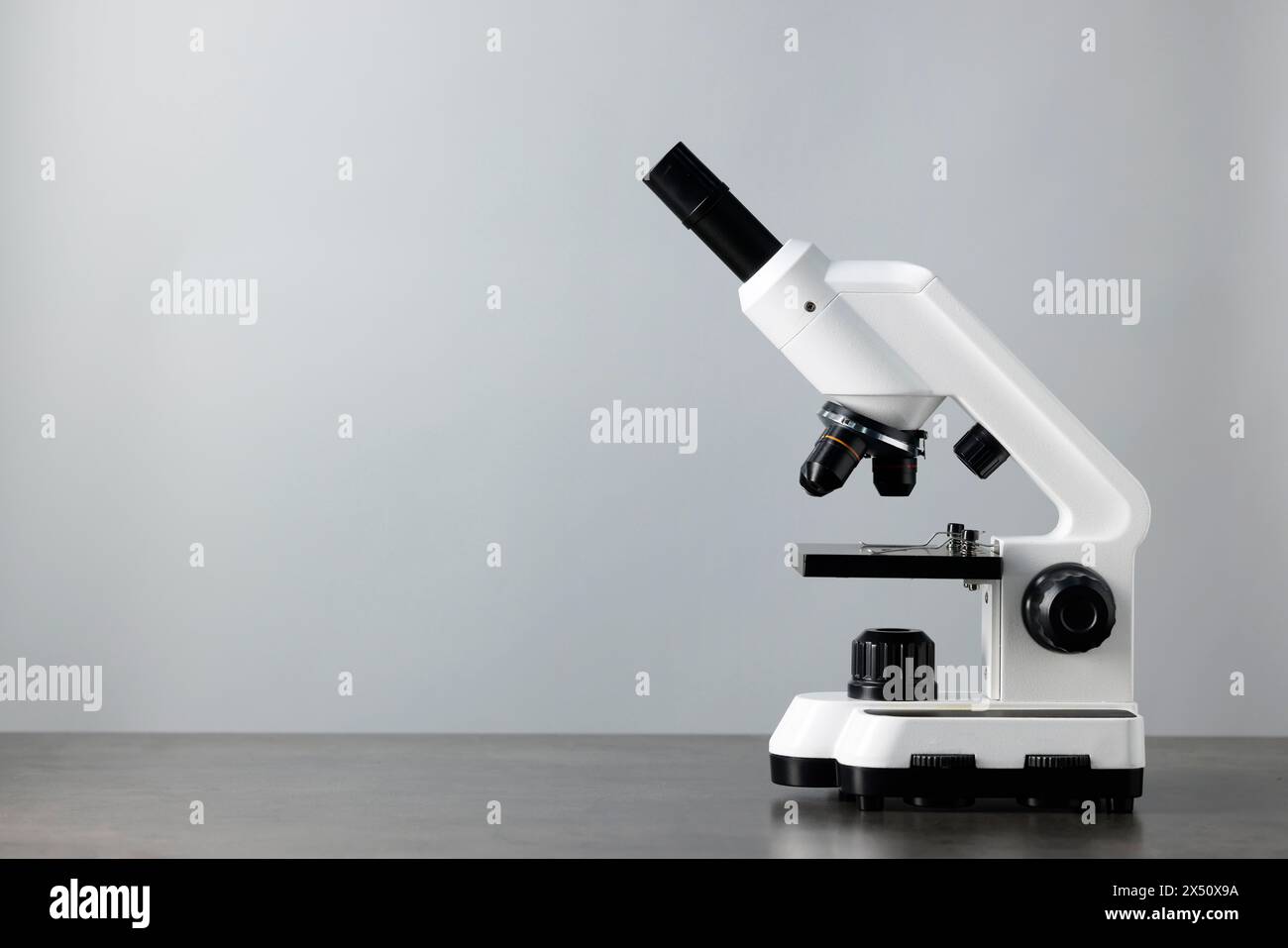 Modern microscope on grey table, space for text Stock Photo - Alamy