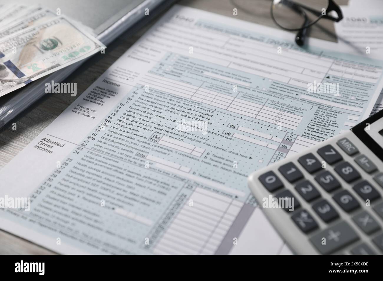 Payroll. Tax return forms, dollar banknotes and calculator on table ...