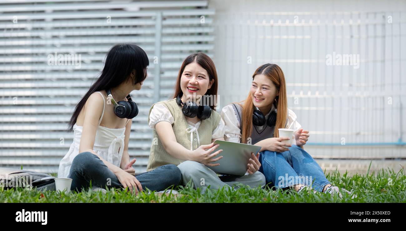 College student having discussion under tree on campus, preparing for ...
