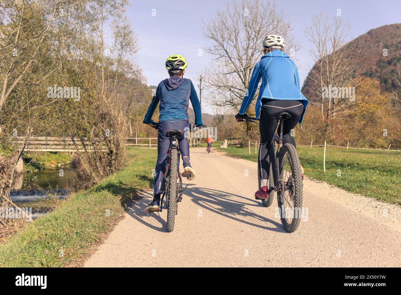 Mother and young son riding bikes along a scenic rural landscape ...