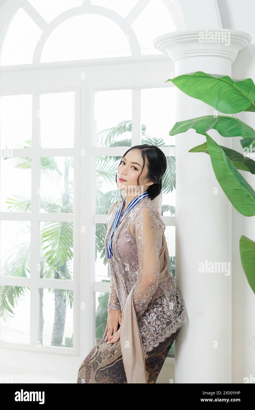 Beautiful Asian Indonesian woman in traditional kebaya clothing posing ...