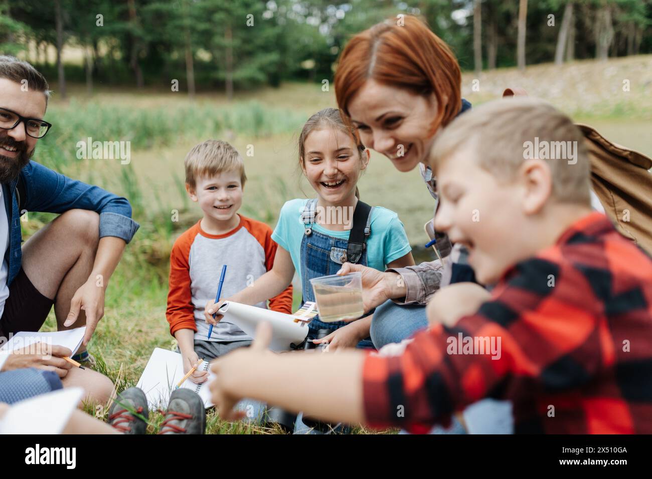 Young students analyzing water quality, ph level with indicator strips ...