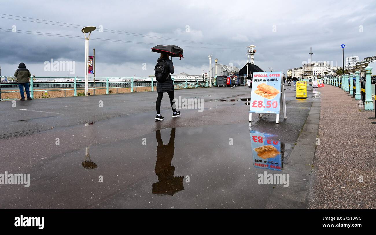 Brighton UK 6th May 2024 - It's umbrella weather for visitors on ...