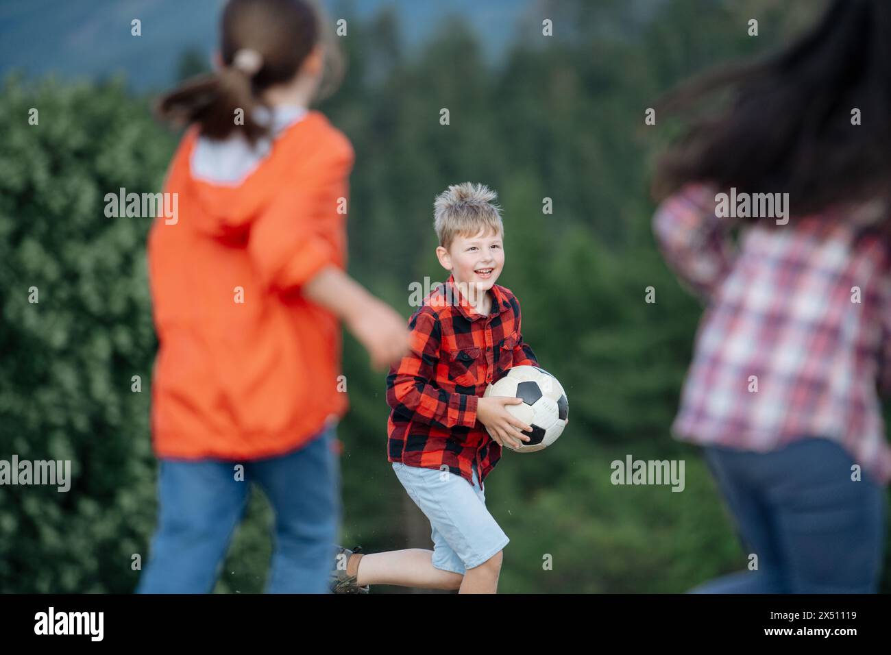 Young students playing with teacher outdoors, in nature, during field ...