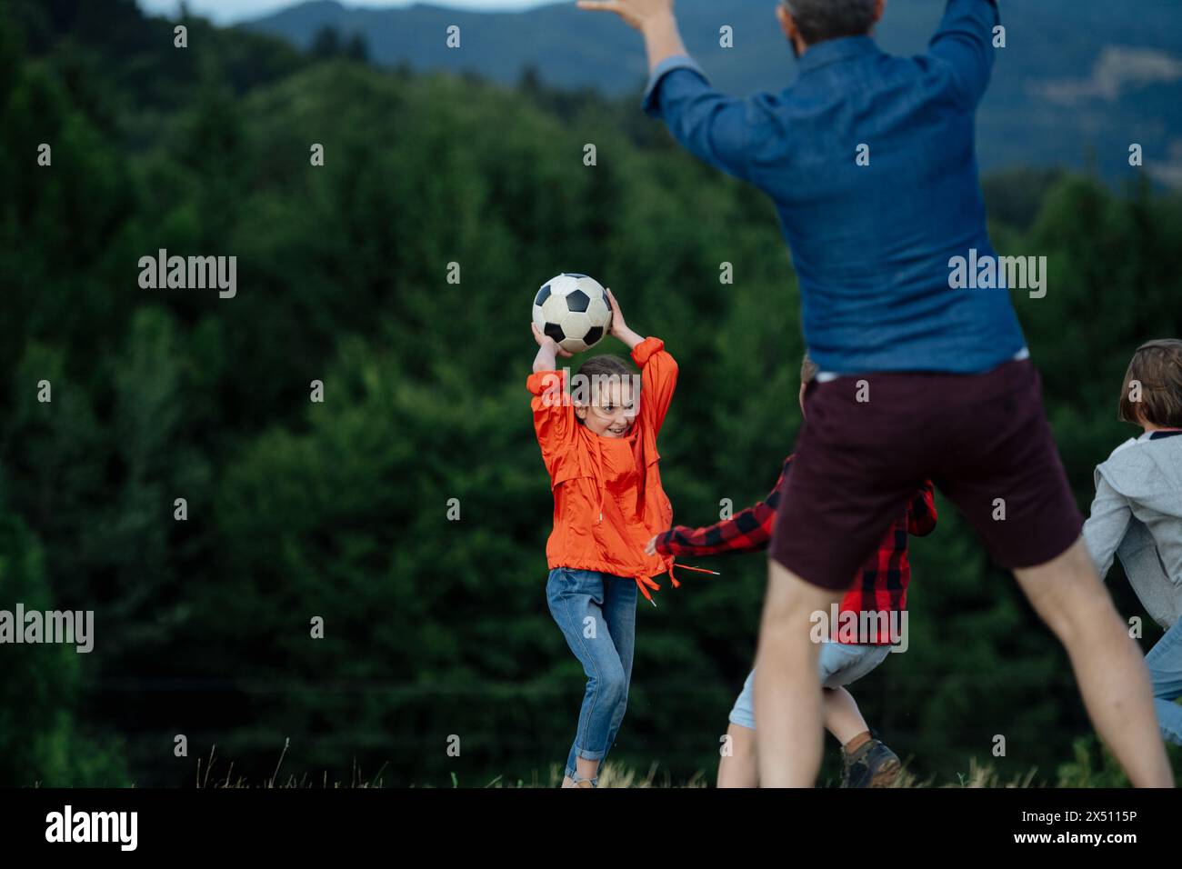 Young students playing with teacher outdoors, in nature, during field ...